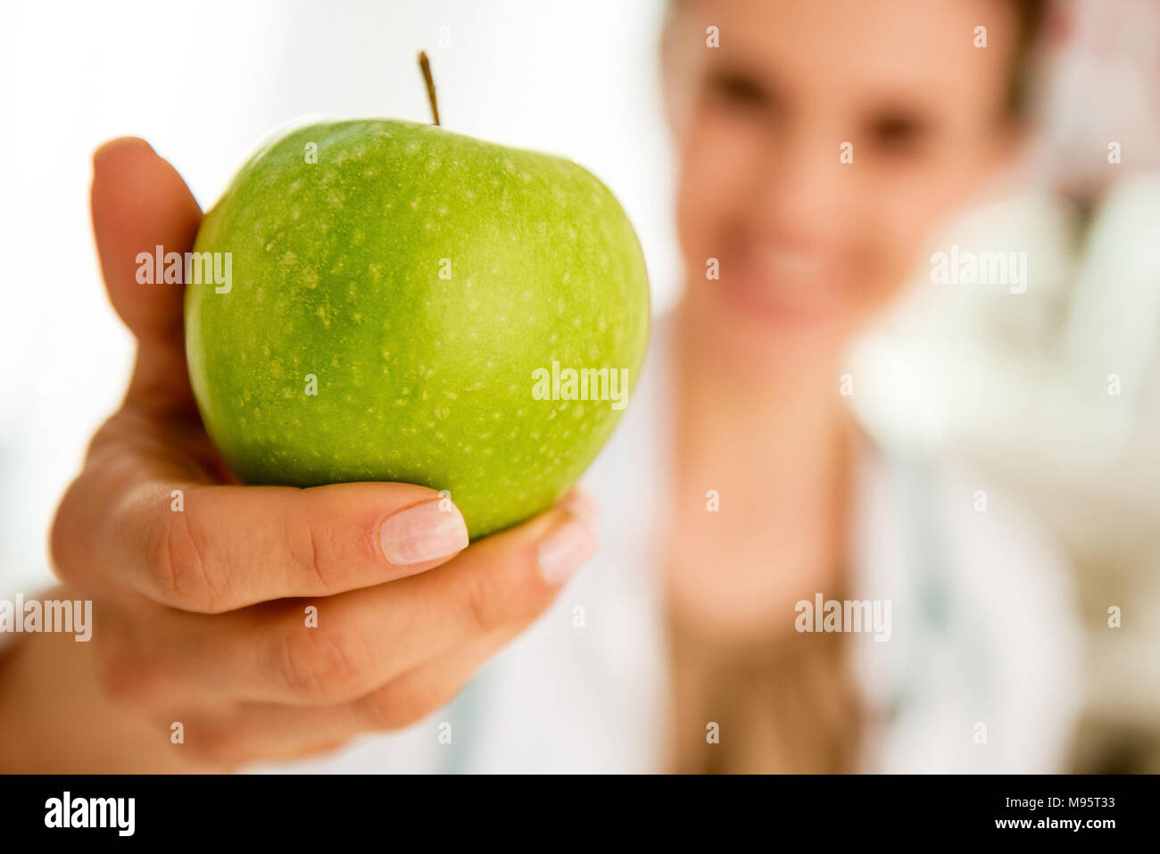 Closeup on happy medical doctor woman giving apple Stock Photo - Alamy