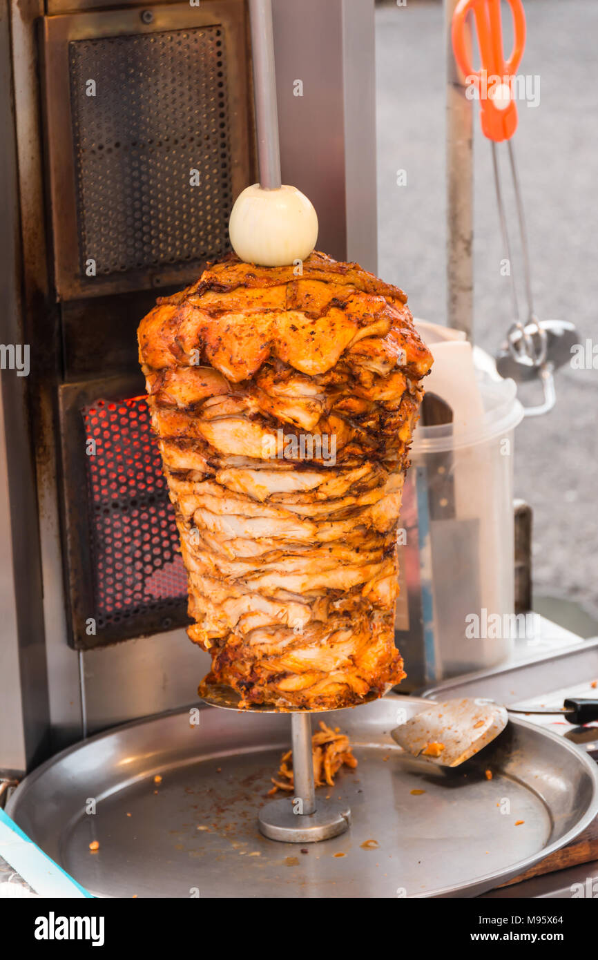 Rotating skewered chicken grilled and ready to serve in a typical ...