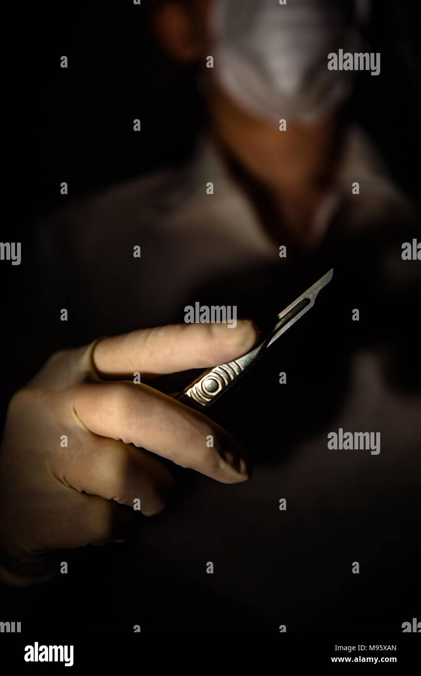 A surgeon holding a scalpel ready for surgery Stock Photo - Alamy
