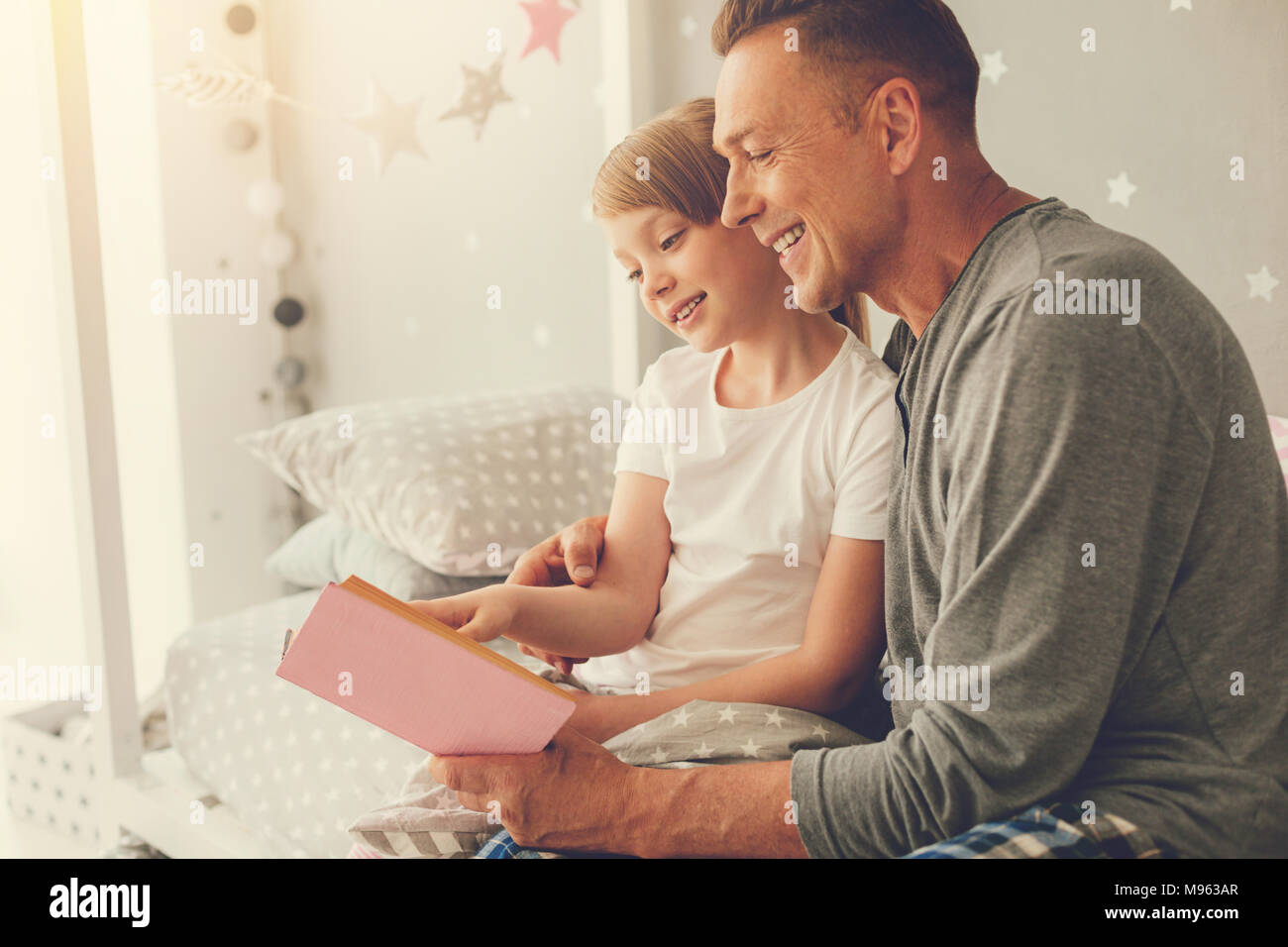 Happy delighted man reading a bedtime story Stock Photo - Alamy
