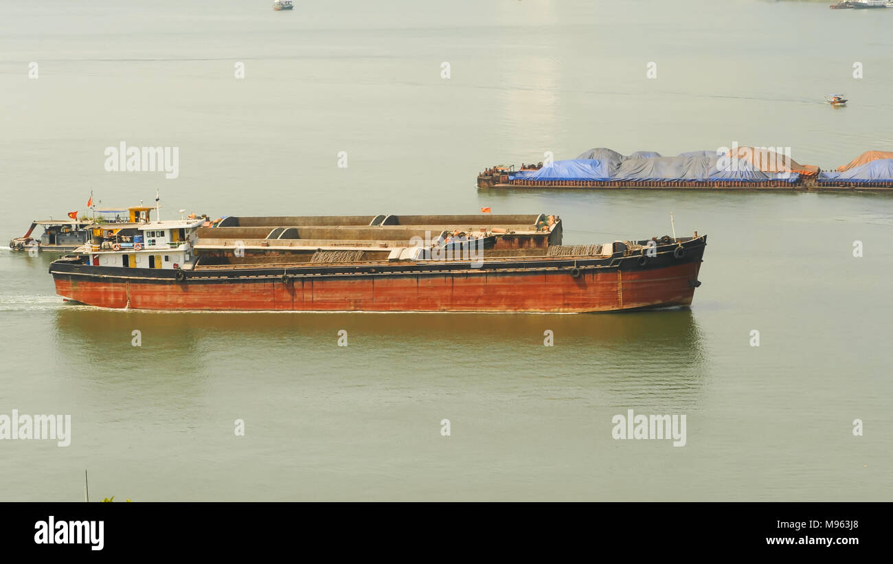 Cargo ships float near each other and transporting building materials ...