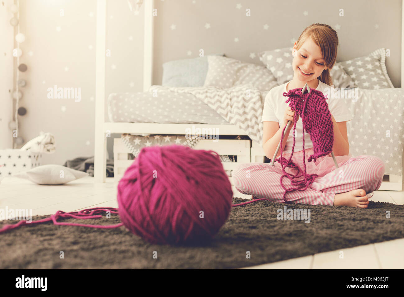Happy cute girl knitting Stock Photo - Alamy