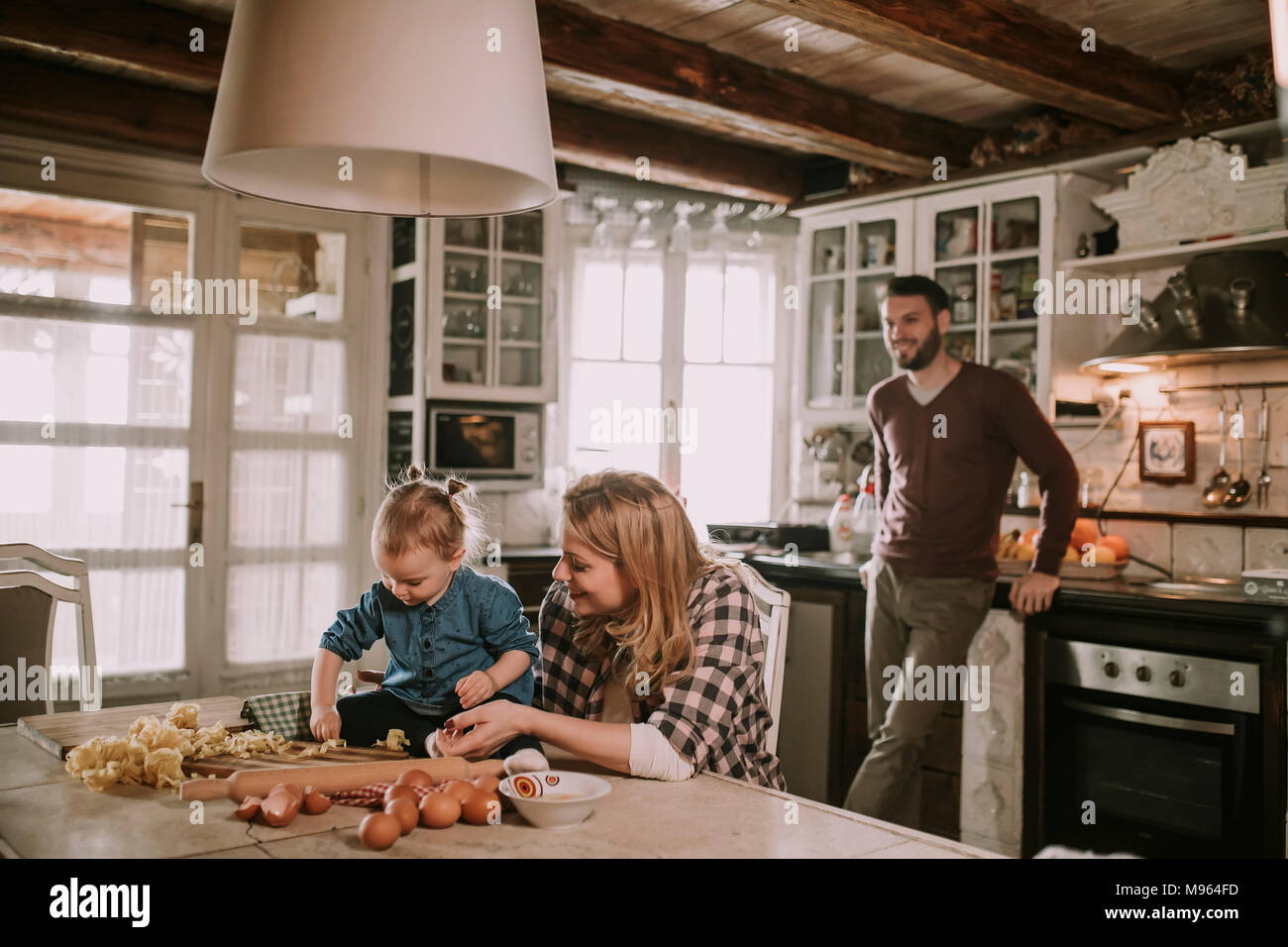 Happy family making pasta in the kitchen at home Stock Photo - Alamy