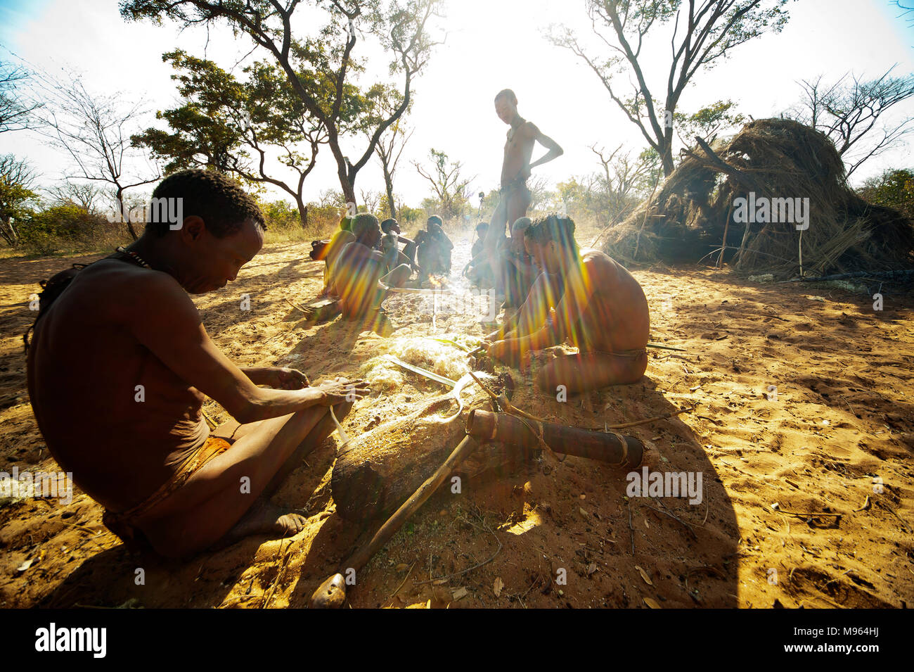 Ju/'Hoansi or San bushmen in daily activities making bow and arrows at ...