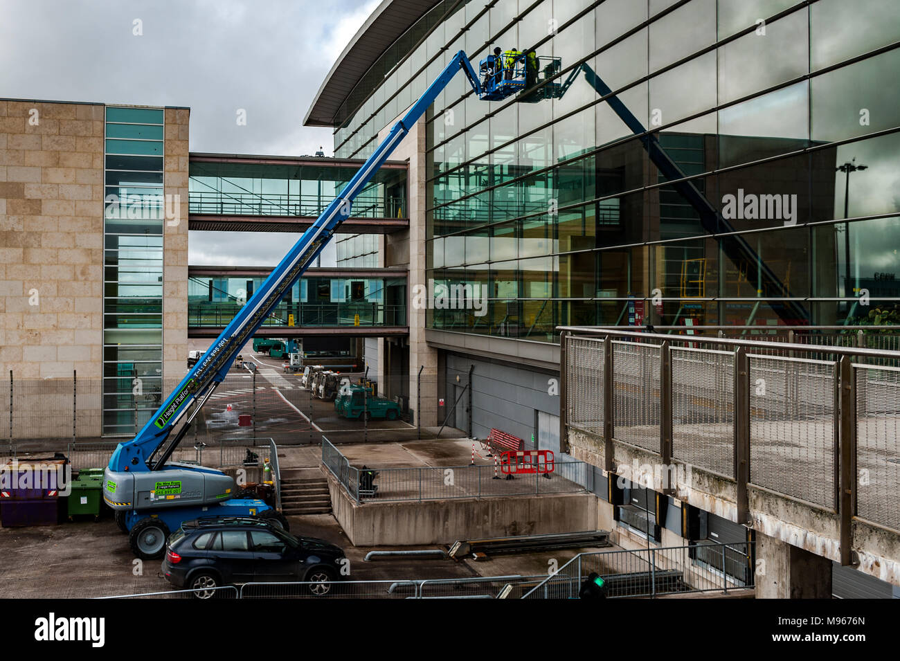 Workmen on a cherry picker repairing a window in the terminal at Cork ...
