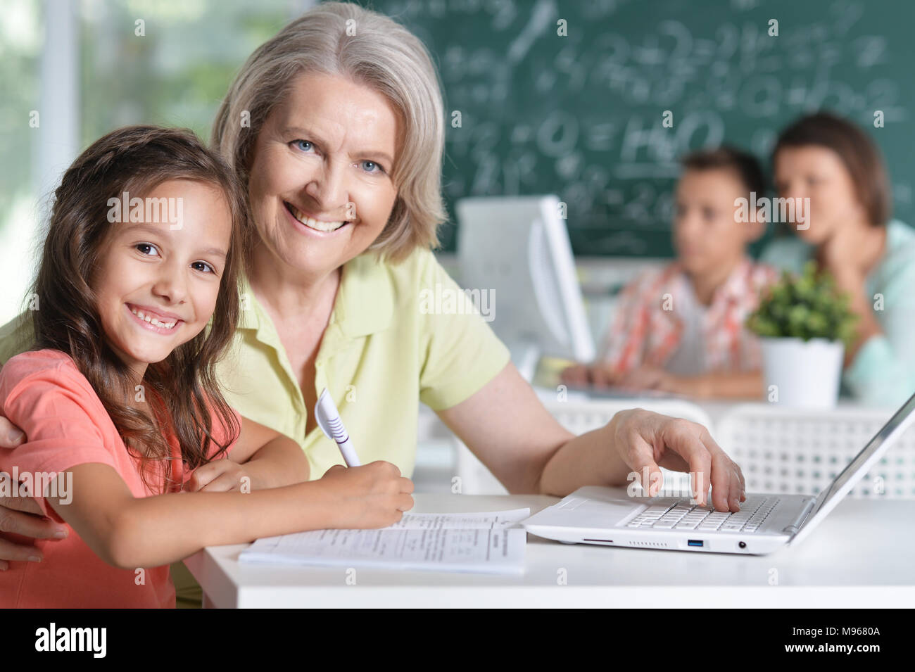 Teachers working with pupils in computer class Stock Photo - Alamy