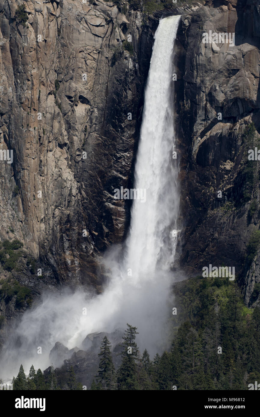 Spring, snow melt gushes over the granite walls of Yosemite valley at ...