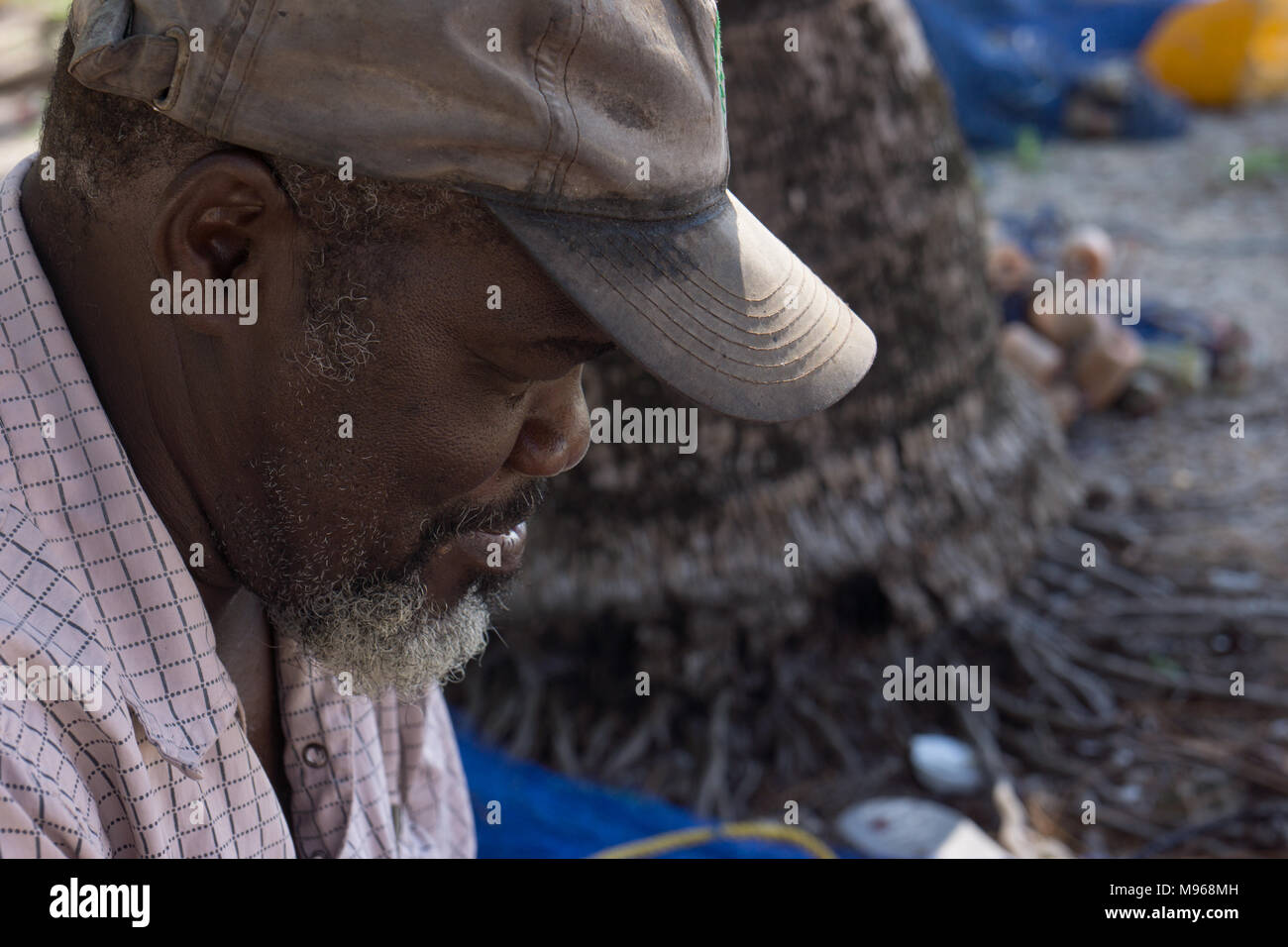 Fisherman on Uzi island, Zanzibar, mending fishing nets on the side of ...