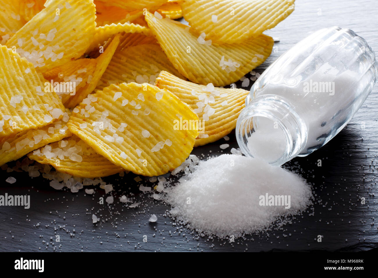 Salt in food - potato chips and salt. Unhealthy food concept Stock ...
