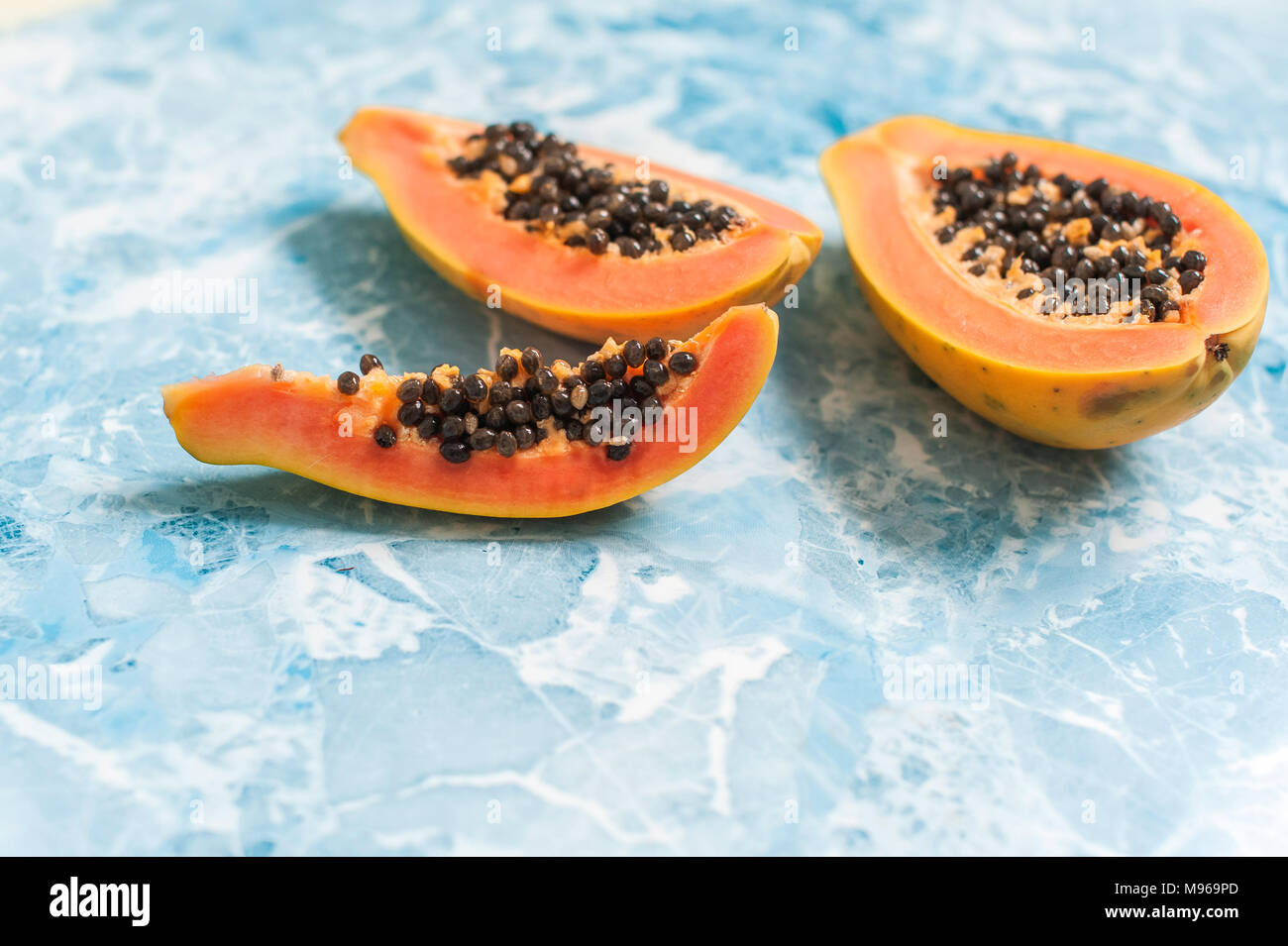 Juicy slices of ripe papaya on a blue background. Exotic fruits ...