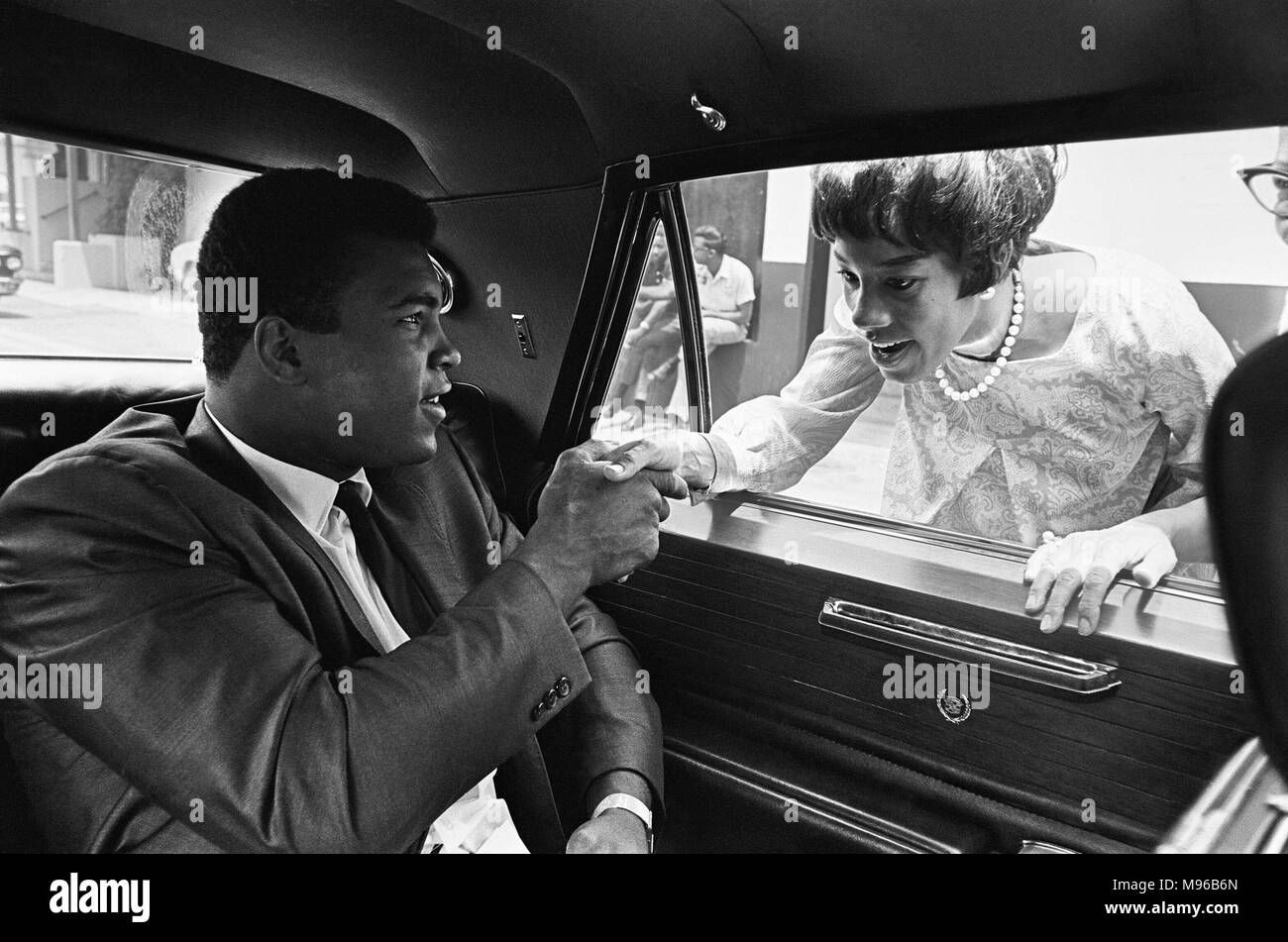 Muhammad Ali shakes a female's hand from his car. 31st August 1967 ...