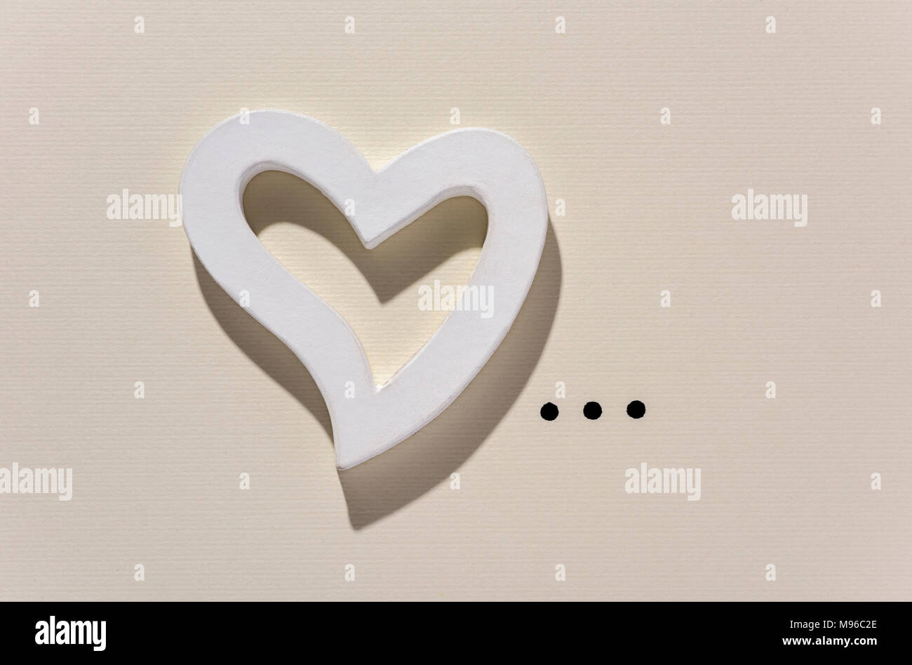 closeup of a white three-dimensional heart and points of ellipsis on an ...