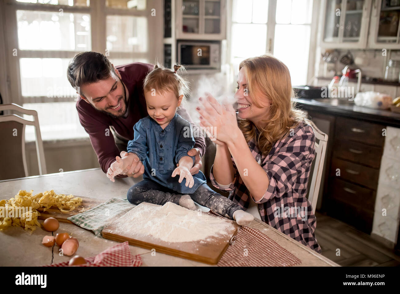 Happy family making pasta in the kitchen at home Stock Photo - Alamy