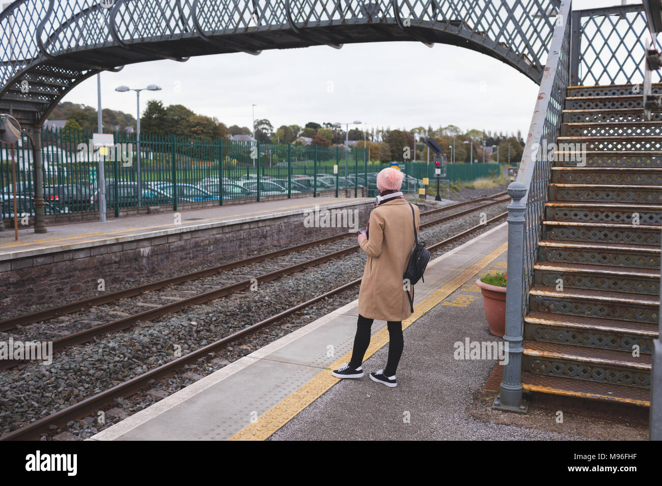 Woman standing on railway station Stock Photo - Alamy