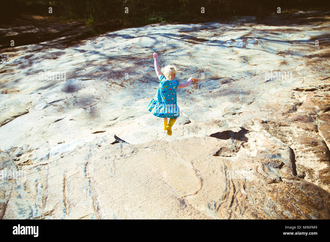 Girl playing on rocks Stock Photo - Alamy