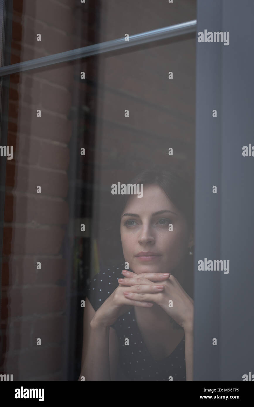Female executive looking through window Stock Photo - Alamy