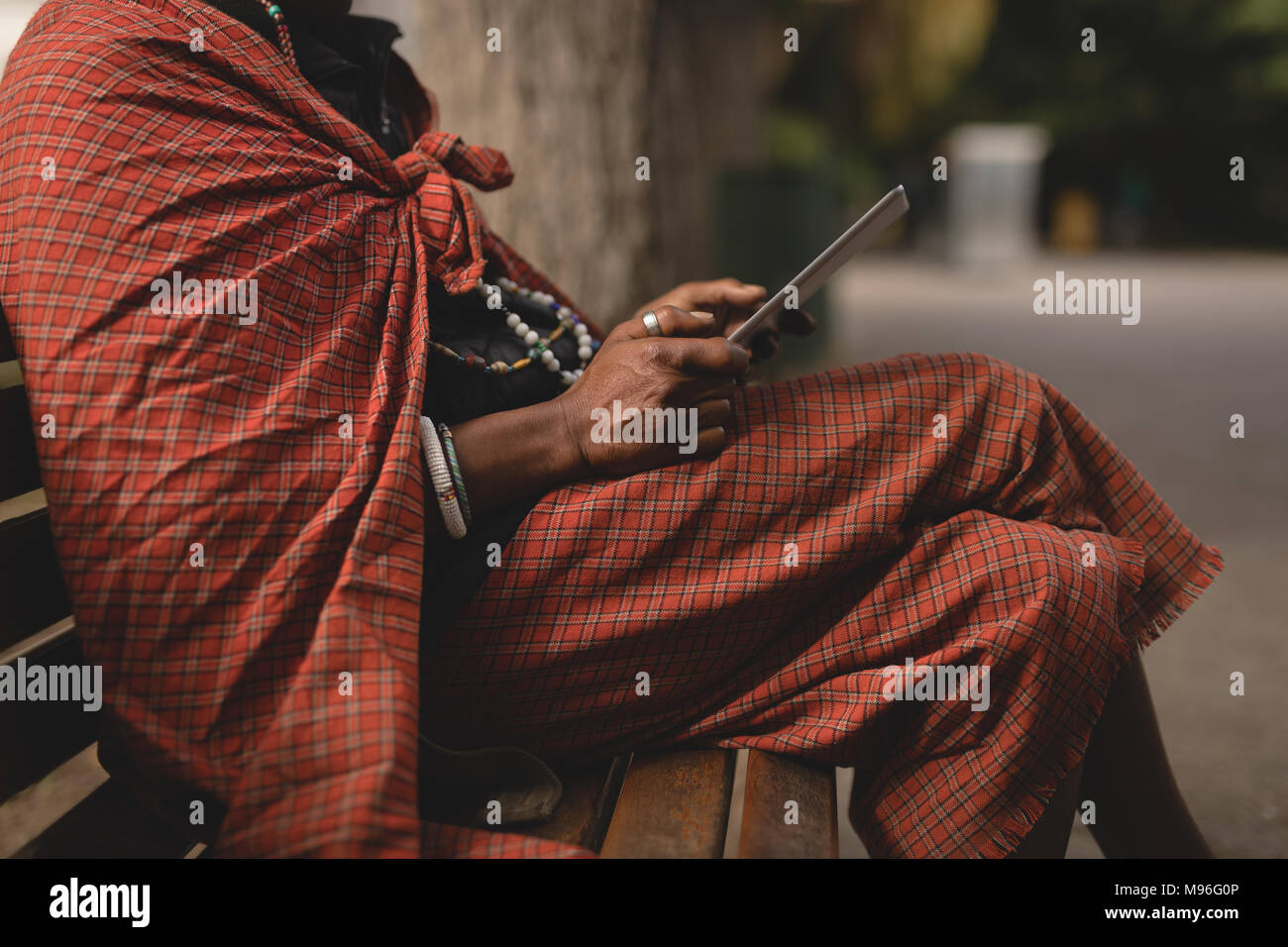 Maasai man in traditional clothing using mobile phone Stock Photo - Alamy