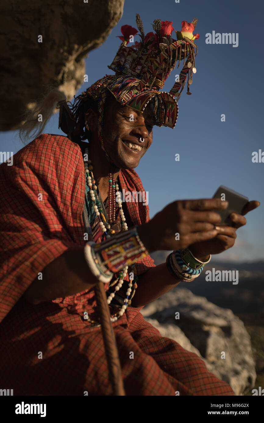 Maasai man in traditional clothing using mobile phone Stock Photo - Alamy