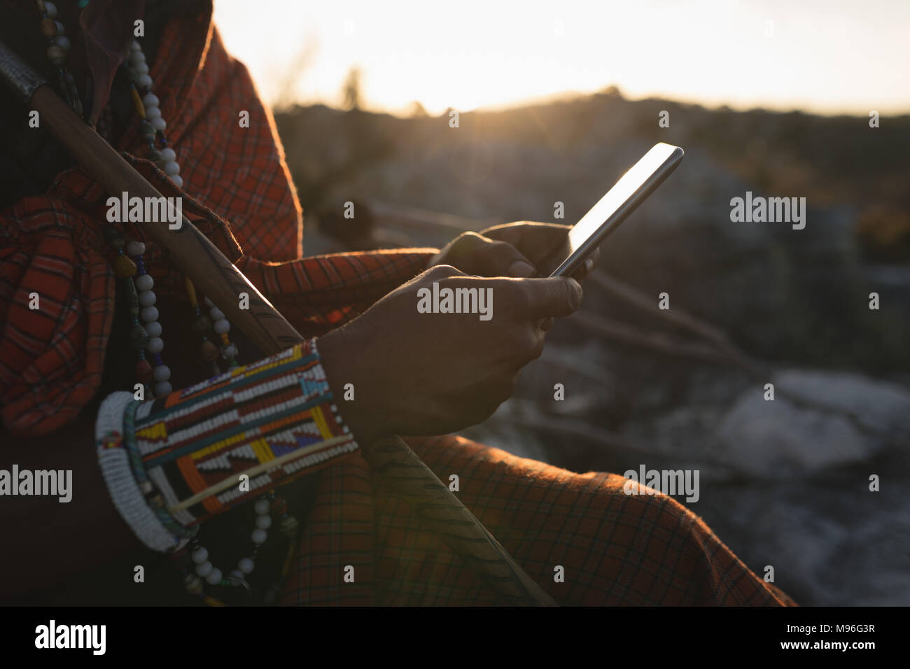Maasai man in traditional clothing using mobile phone Stock Photo - Alamy