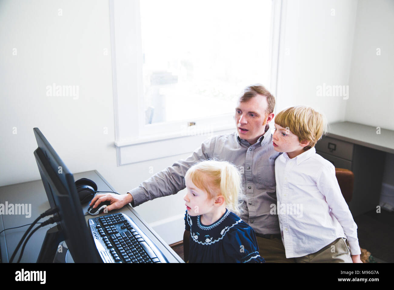 Family looking at computer Stock Photo - Alamy