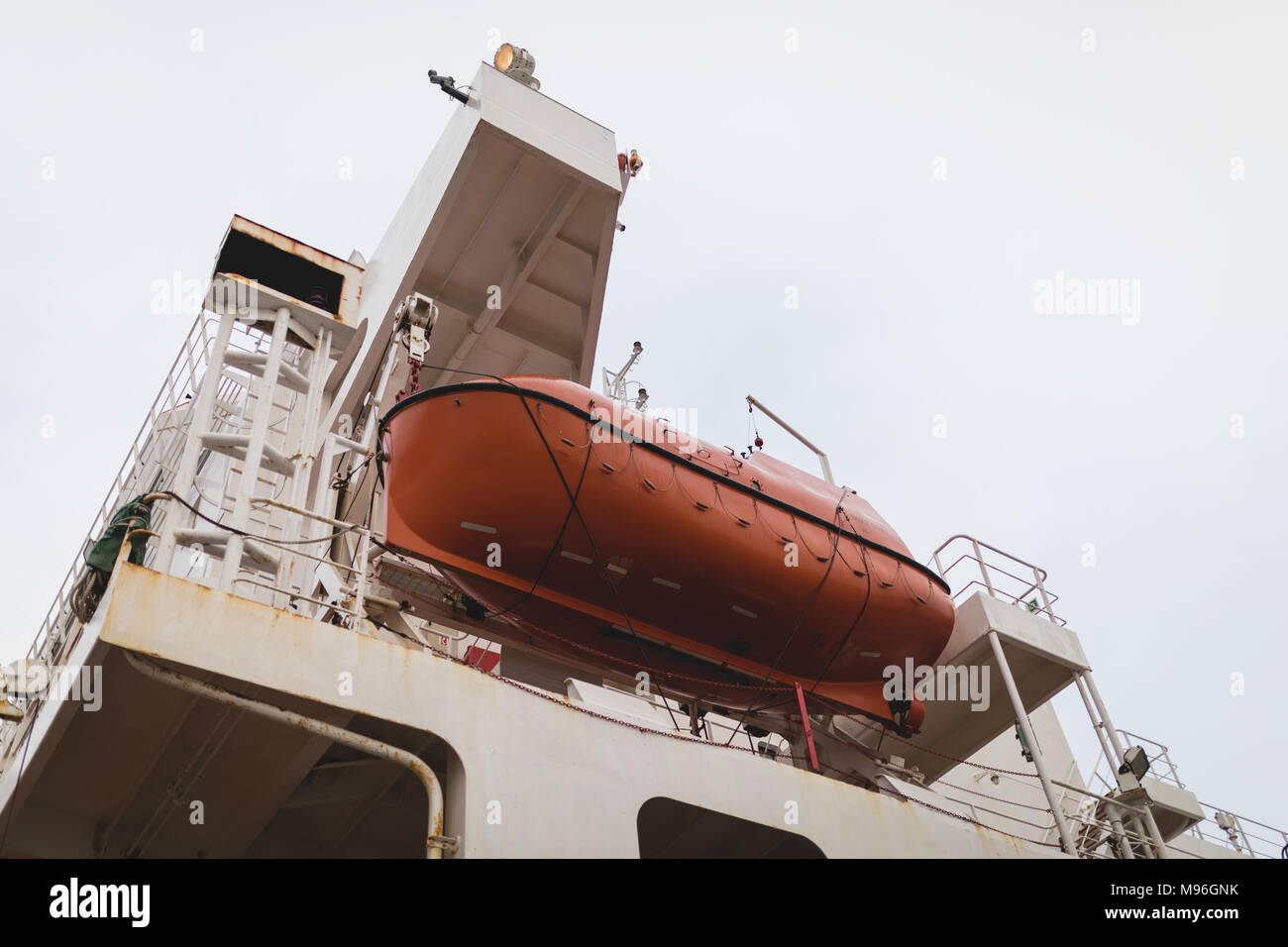 Rescue boat and a lifeboat hanging on a side of a ship Stock Photo - Alamy