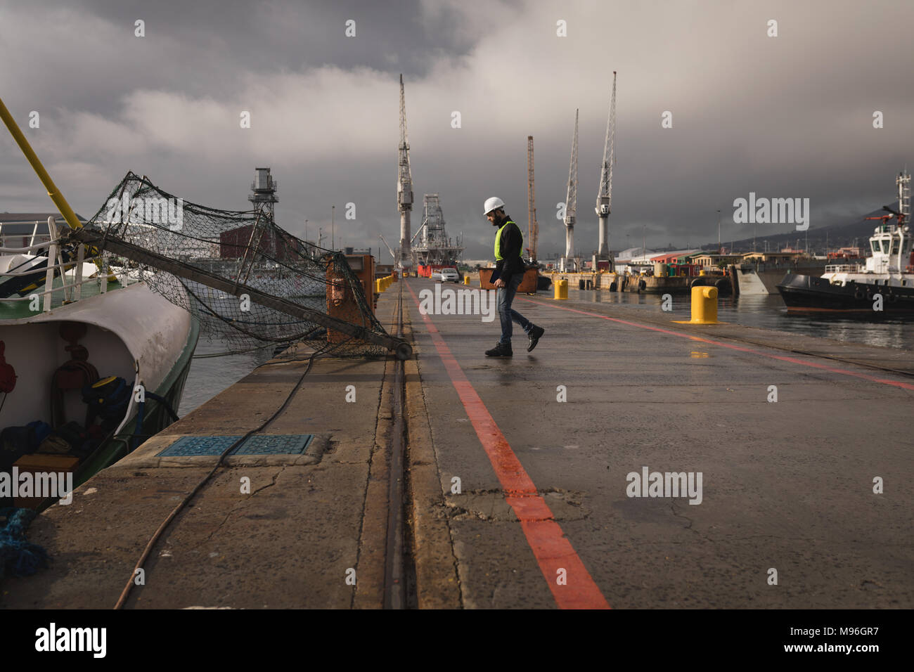 Dock worker walking in the shipyard Stock Photo - Alamy