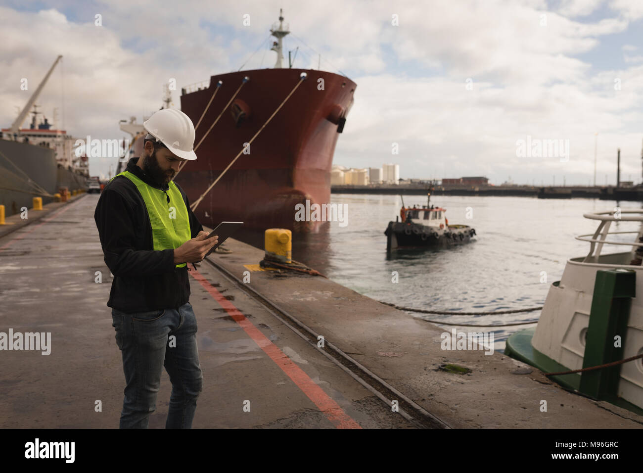 Dock worker using digital tablet Stock Photo - Alamy