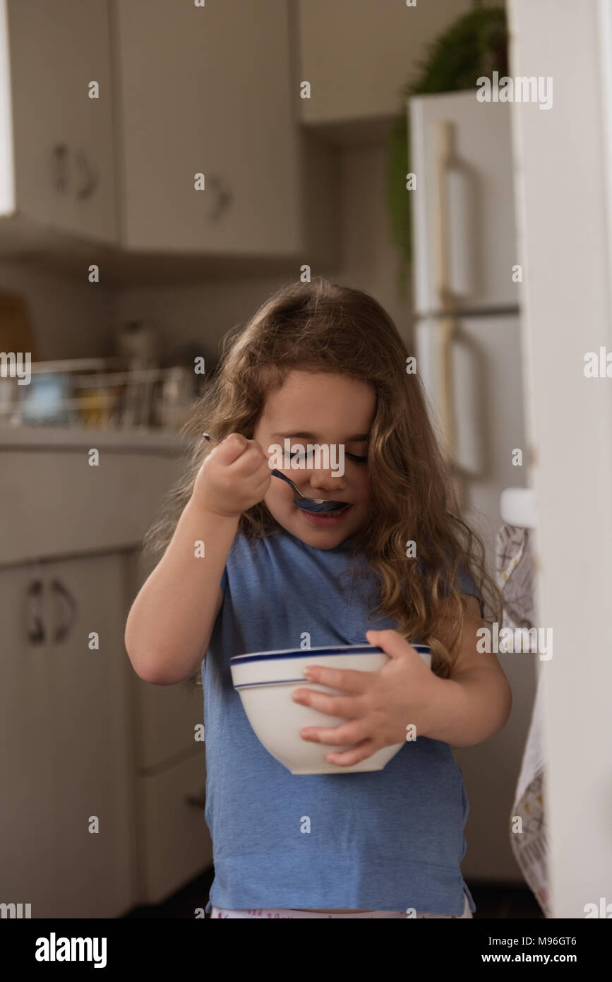 Young girl eating from a bowl Stock Photo - Alamy