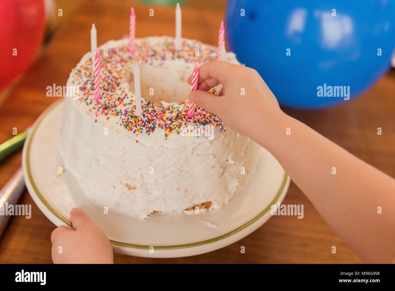 Girl putting candle on birthday cake Stock Photo - Alamy