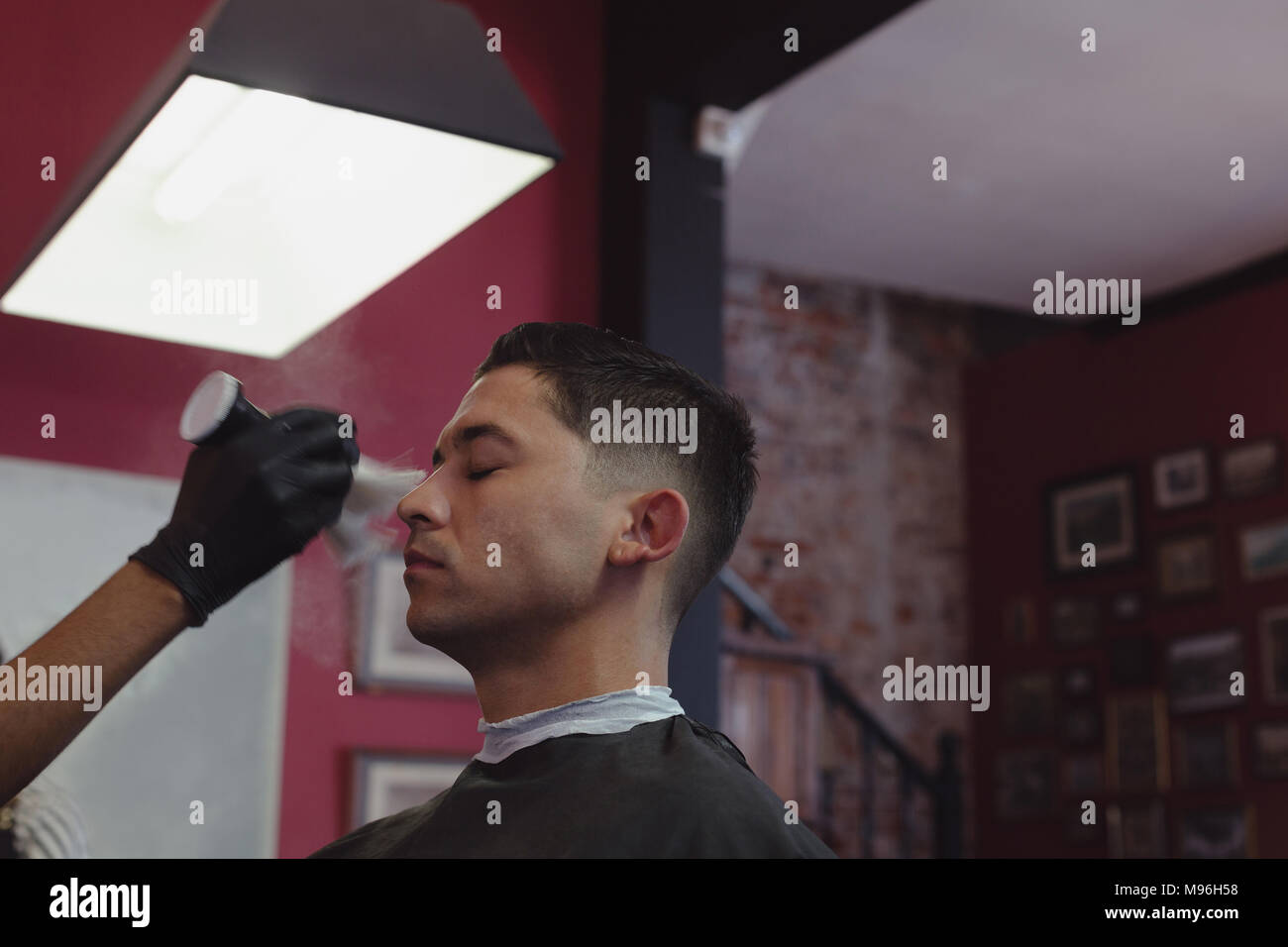 Barber cleaning customer face with brush Stock Photo - Alamy