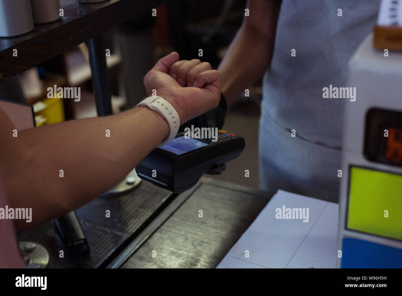 Customer making payment through smartwatch Stock Photo - Alamy