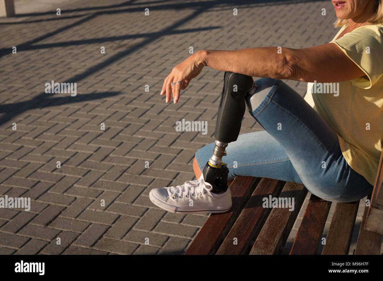 Disabled woman relaxing on bench near beach Stock Photo - Alamy