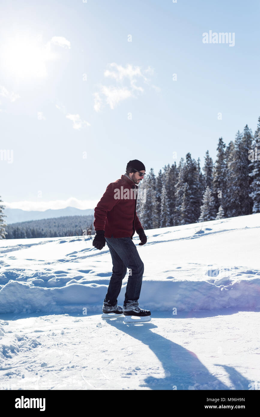 Man skating in snowy landscape Stock Photo - Alamy