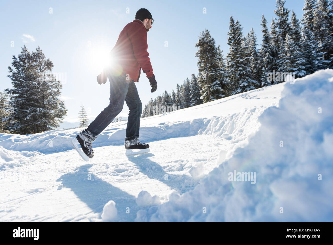 Man skating in snowy landscape Stock Photo - Alamy