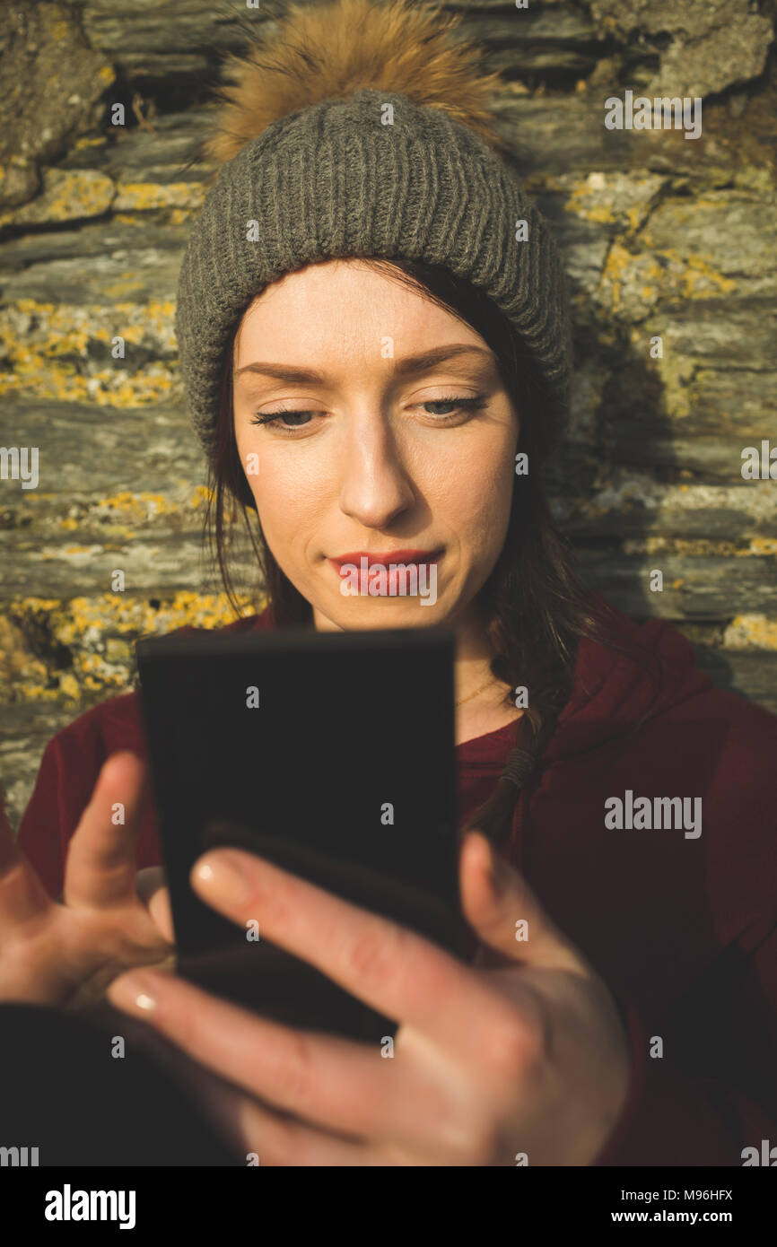 Old woman sitting against wall hi-res stock photography and images - Alamy