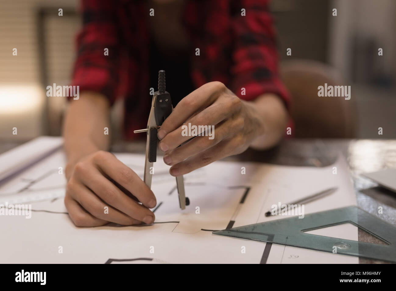 Female welder using compass in workshop Stock Photo - Alamy