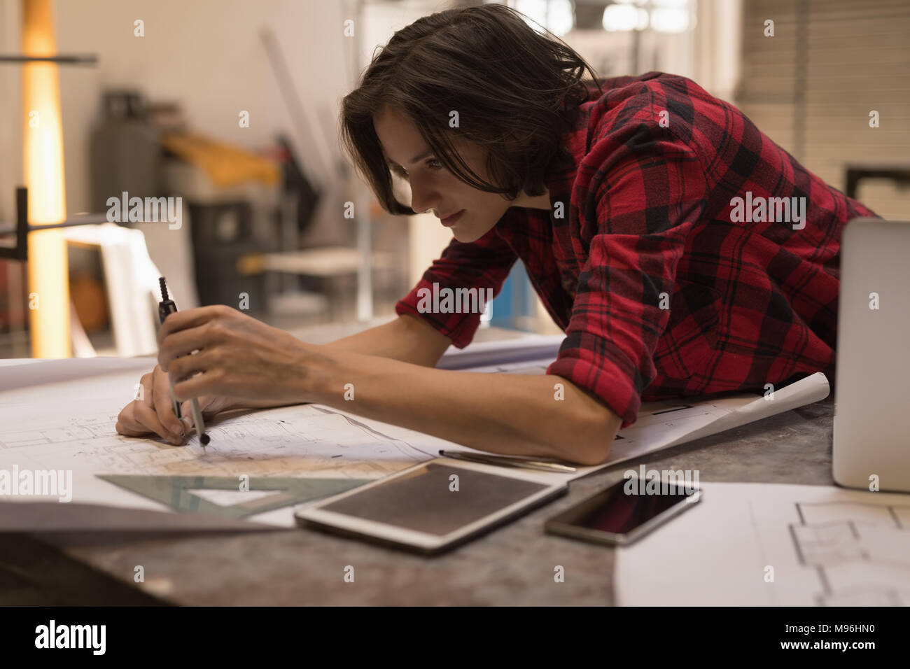 Female welder using compass in workshop Stock Photo - Alamy