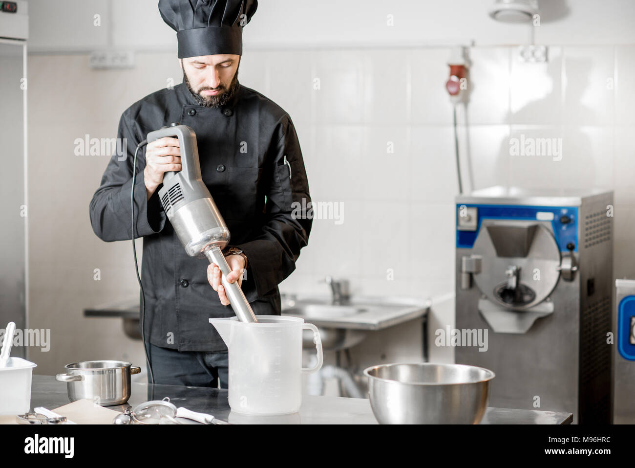 Chef cook mixing milk with sugar with professional blender for ice ...