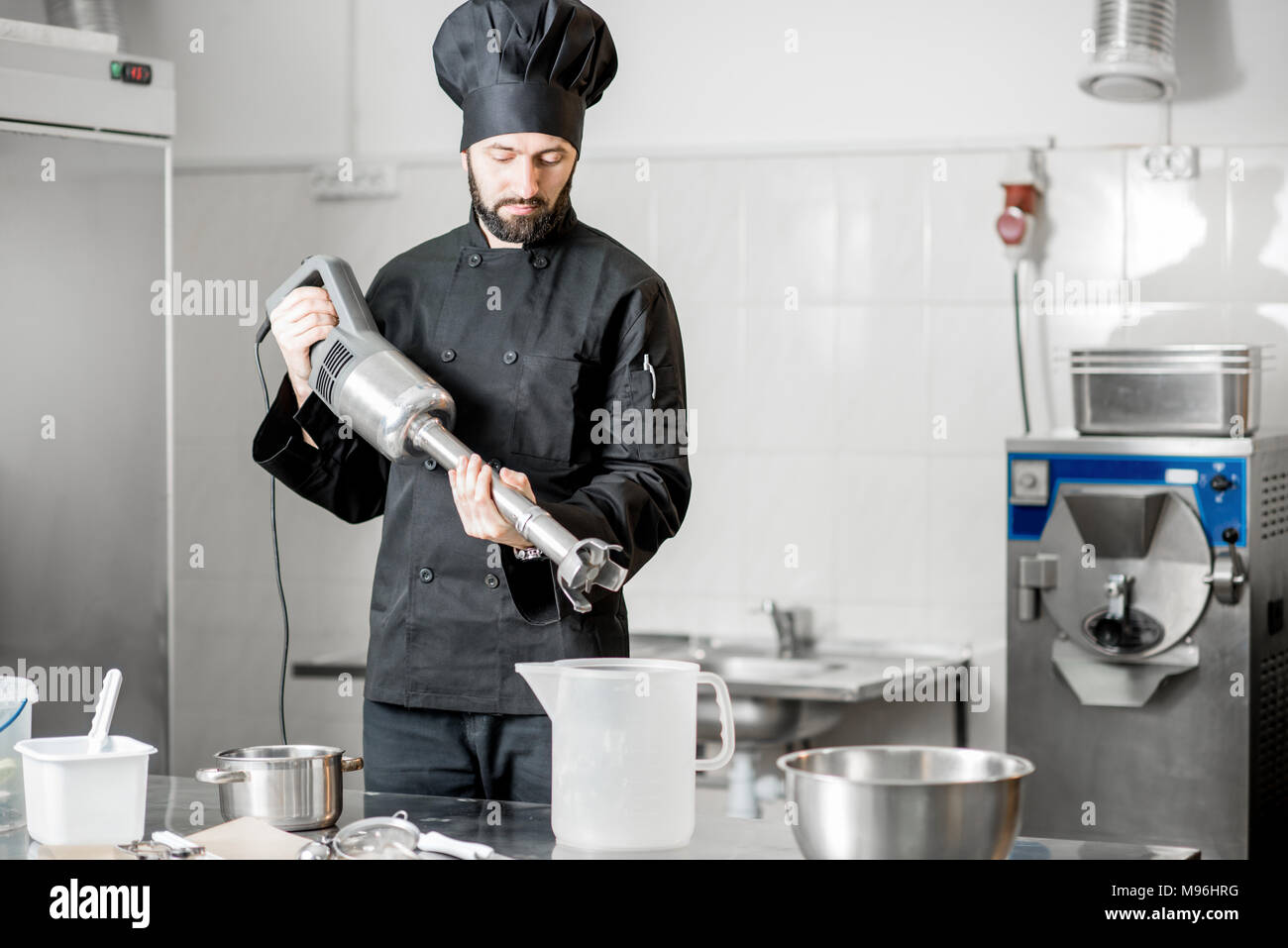 Chef cook mixing milk with sugar with professional blender for ice ...