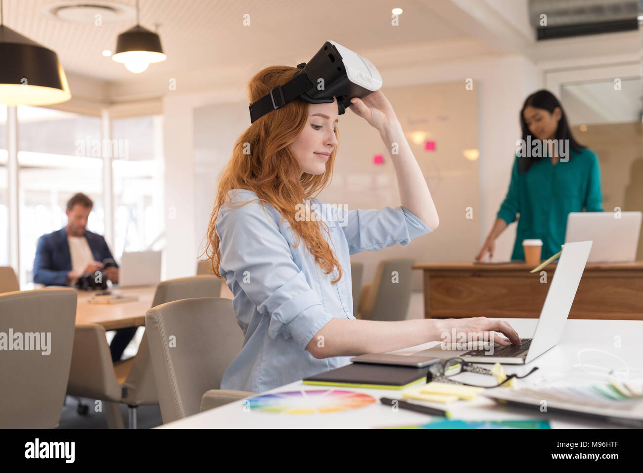Female graphic designer with virtual reality headset using laptop Stock ...