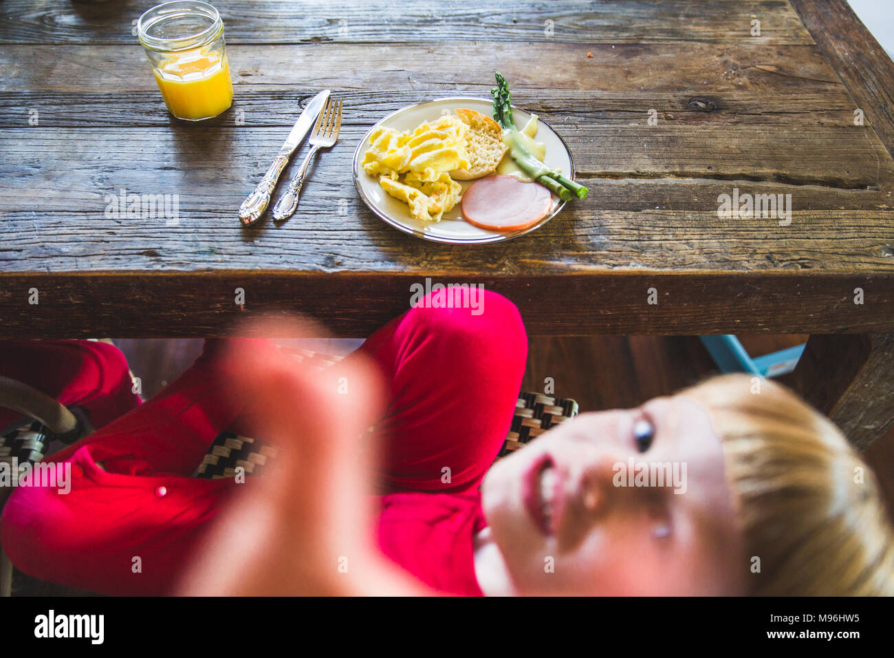 Boy looking up at camera with food ready on the table Stock Photo - Alamy