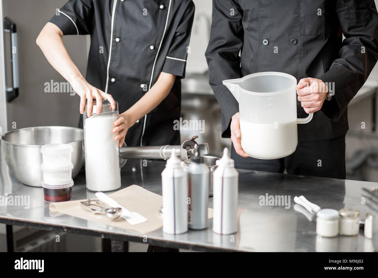 Chefs mixing ingredients for ice cream production in the professional ...