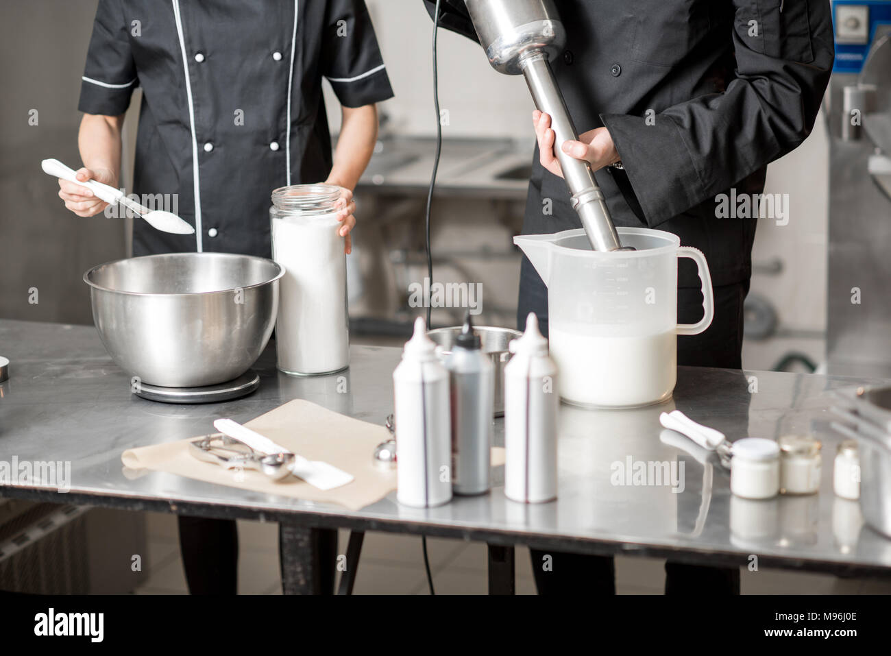 Chefs mixing ingredients for ice cream production in the professional ...