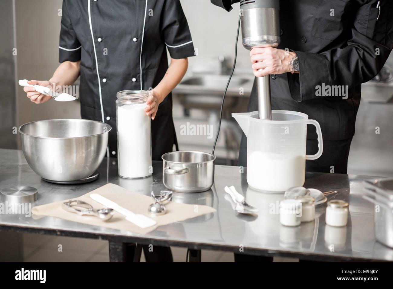 Chefs mixing ingredients for ice cream production in the professional ...