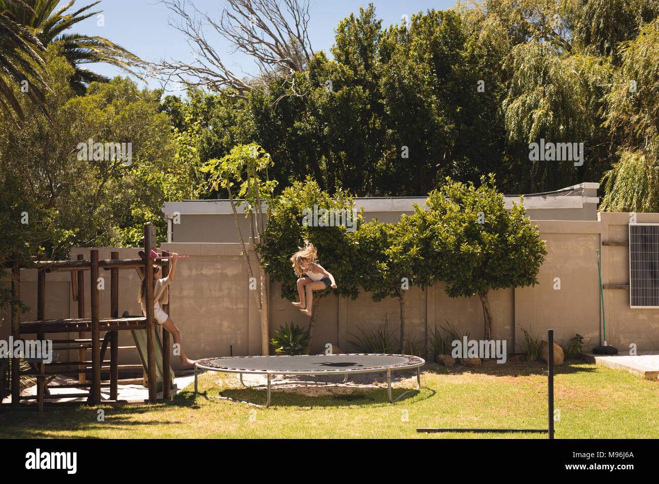 Girl jumping on trampoline in the garden Stock Photo - Alamy