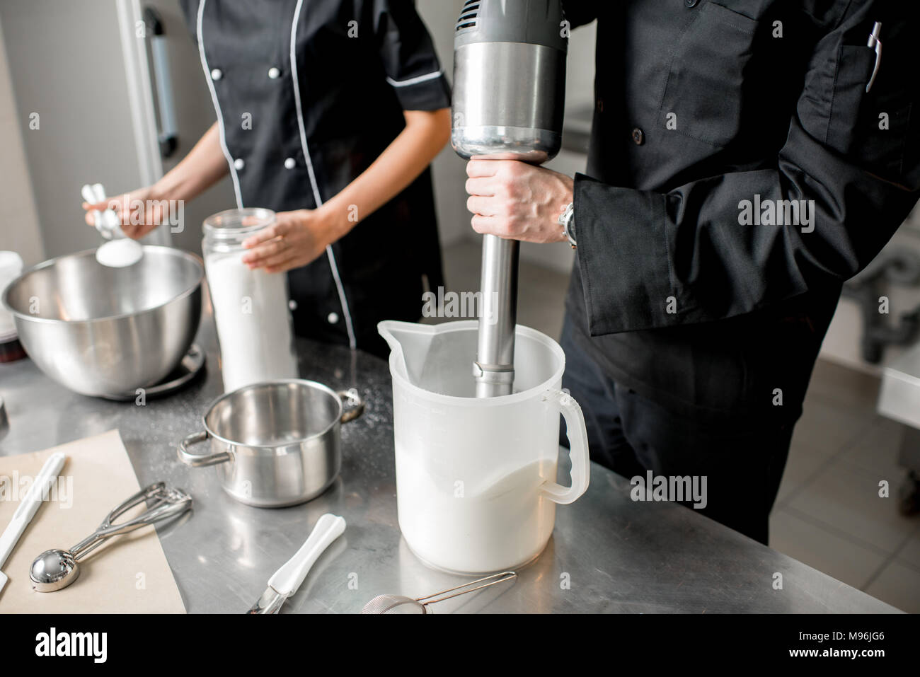 Chefs mixing ingredients for ice cream production in the professional ...