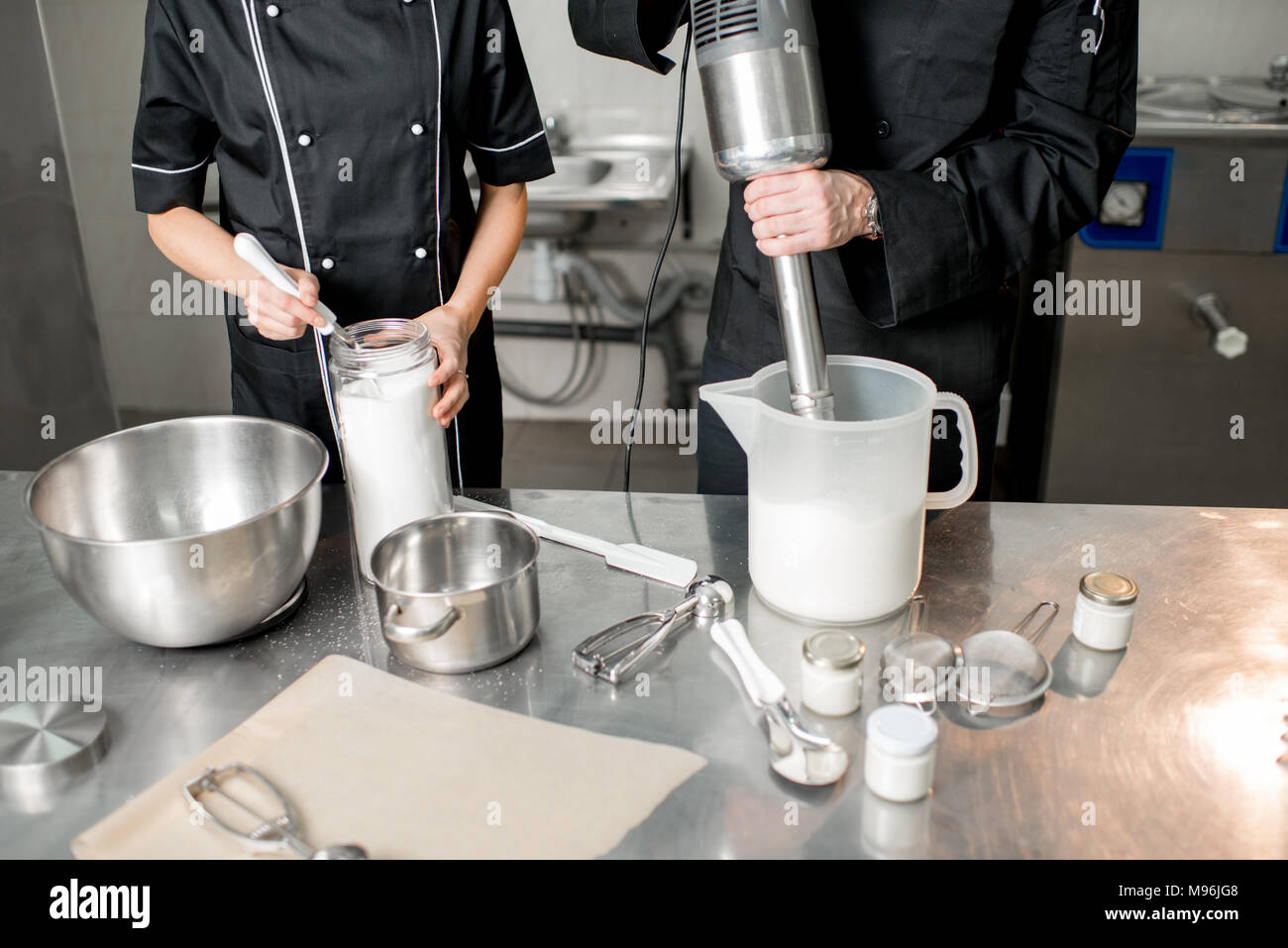 Chefs mixing ingredients for ice cream production in the professional ...