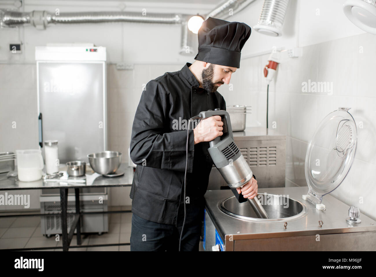 Chef cook mixing milk in pasteurization machine prepairing basis for ...