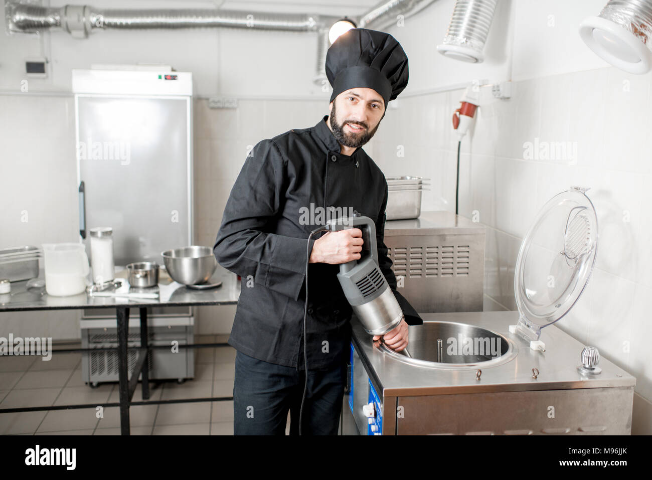 Chef cook mixing milk in pasteurization machine prepairing basis for ...