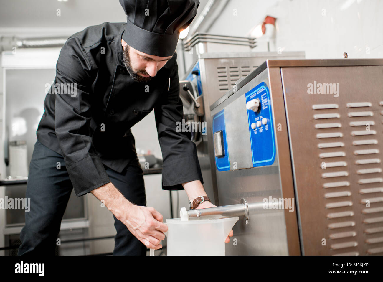 Chef pouring pasteurized milk into the jar for ice cream production ...